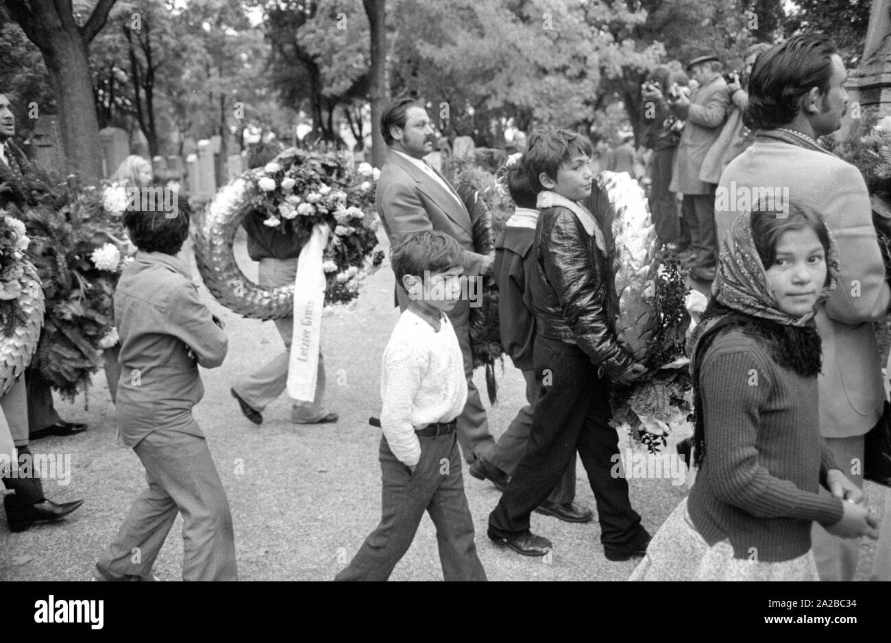 Relatives with wreaths follow the coffin during the procession over the ...