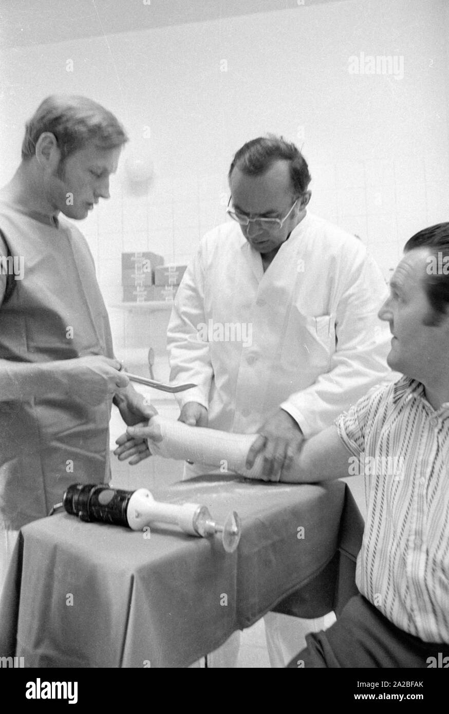 A doctor prepares to remove a plaster. This is presumably a cast from ...