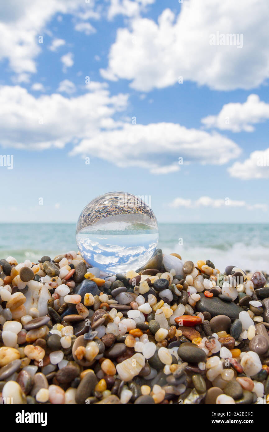 Glass round ball on the beach reflects the sea in summer Stock Photo ...