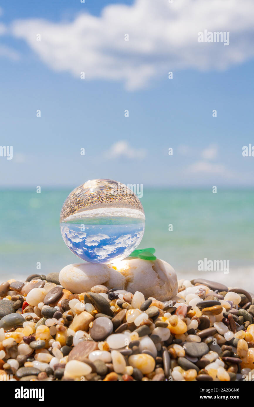 Glass round ball on the beach reflects the sea in summer Stock Photo ...