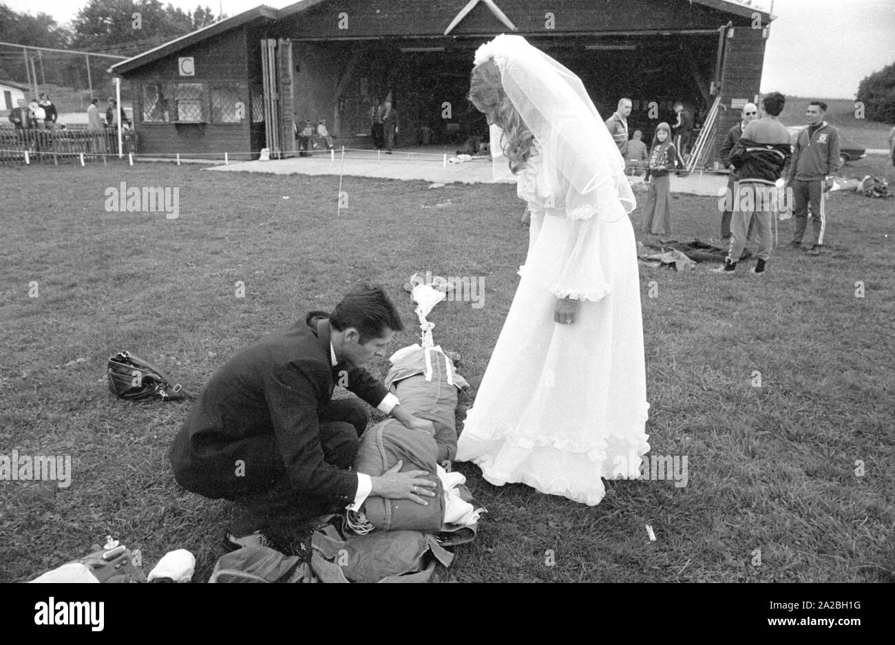 The bride and groom get ready for the parachute jump and their ...
