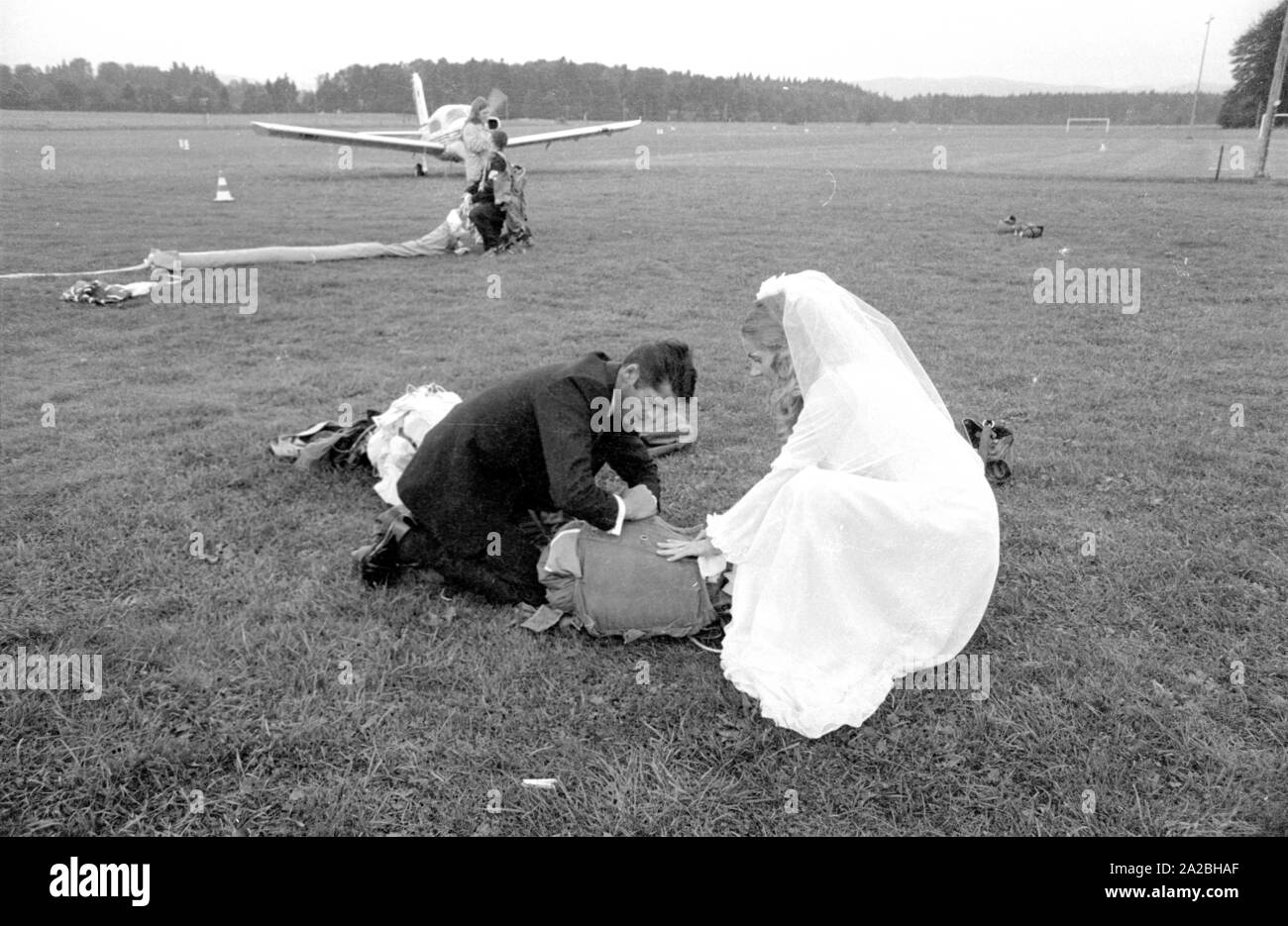 The bride and groom get ready for the parachute jump and their ...