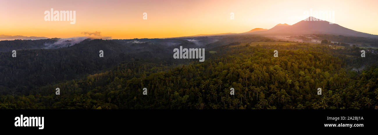 Majestic volcano at sunrise surrounded by dense rainforest Stock Photo ...