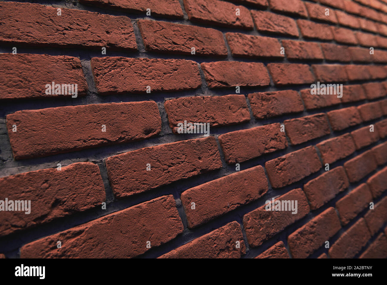 An orange brick wall at an angle with bokeh. Stone blurred background ...