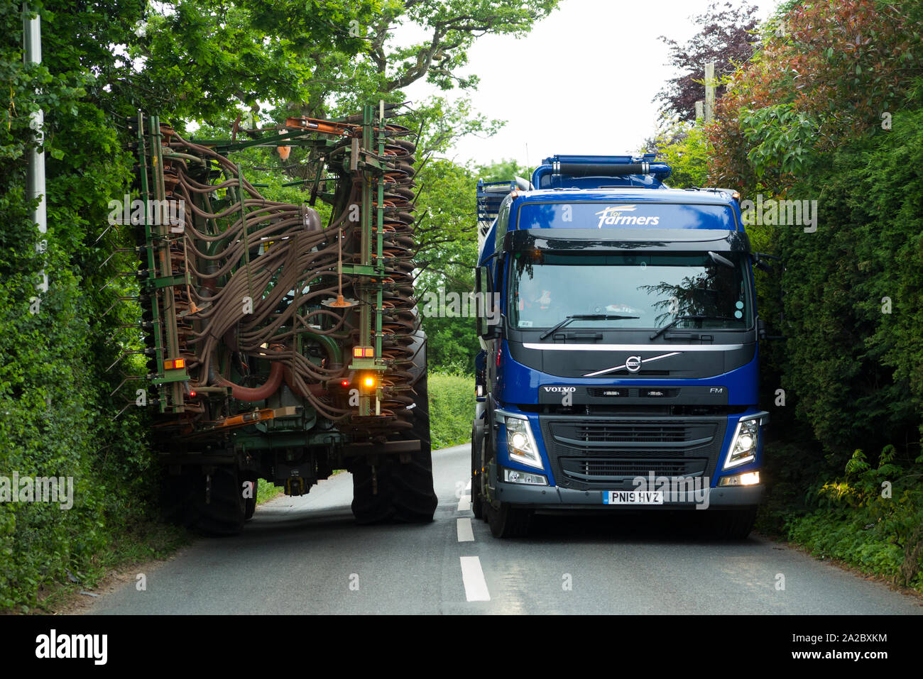 HGV lorry heavy goods vehicle passing a tractor towing agricultural ...