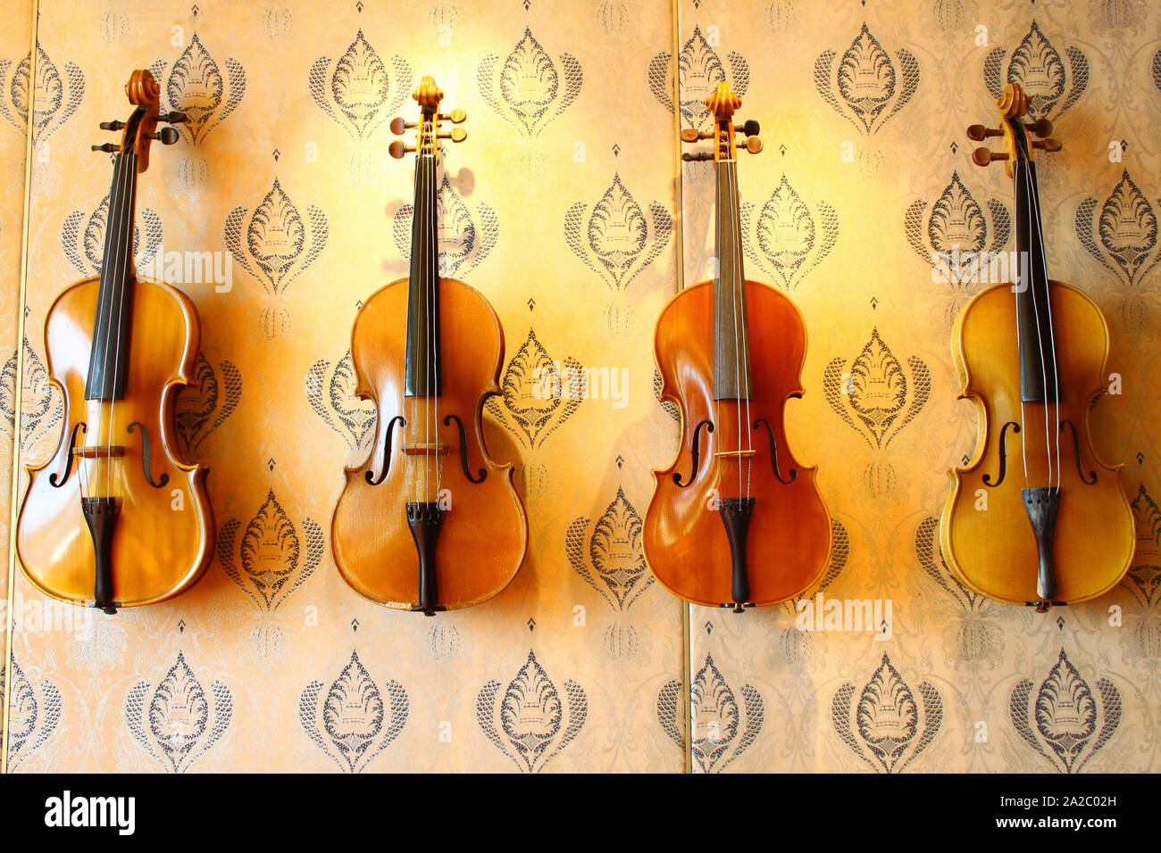 A row of 4 violins on a wall Stock Photo - Alamy