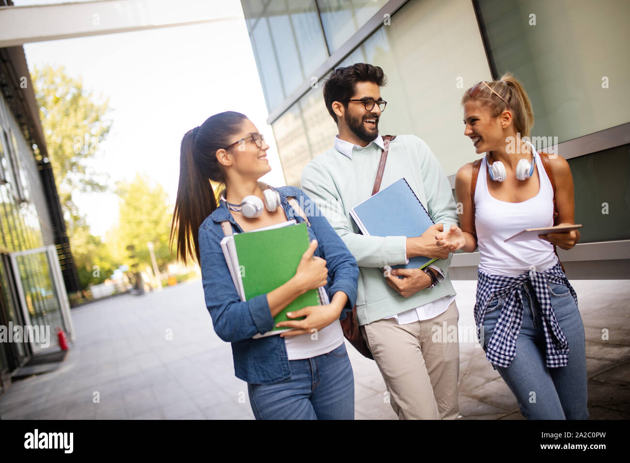 Happy university friends studying together in college Stock Photo - Alamy