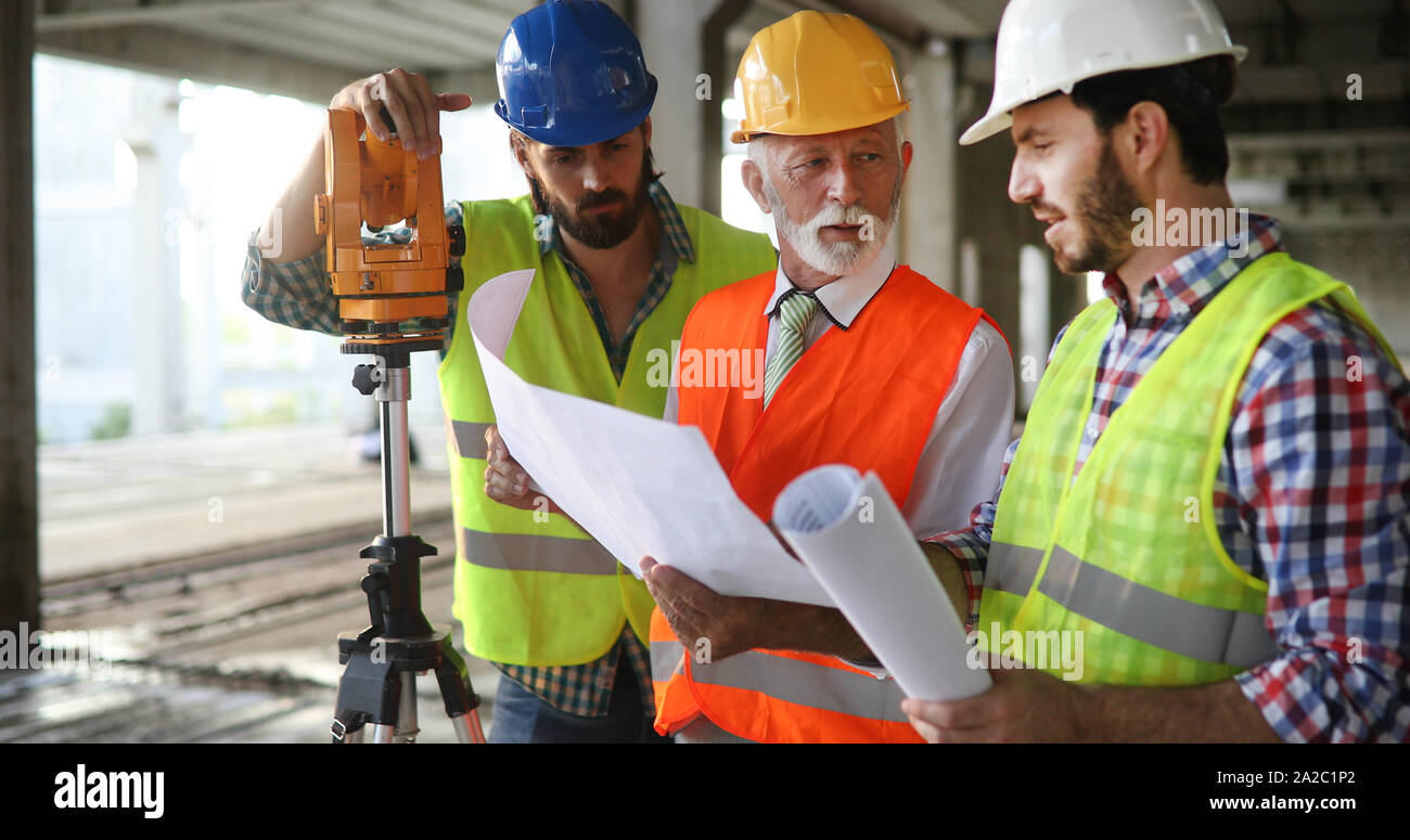 Team of construction engineers, architects working on building site ...