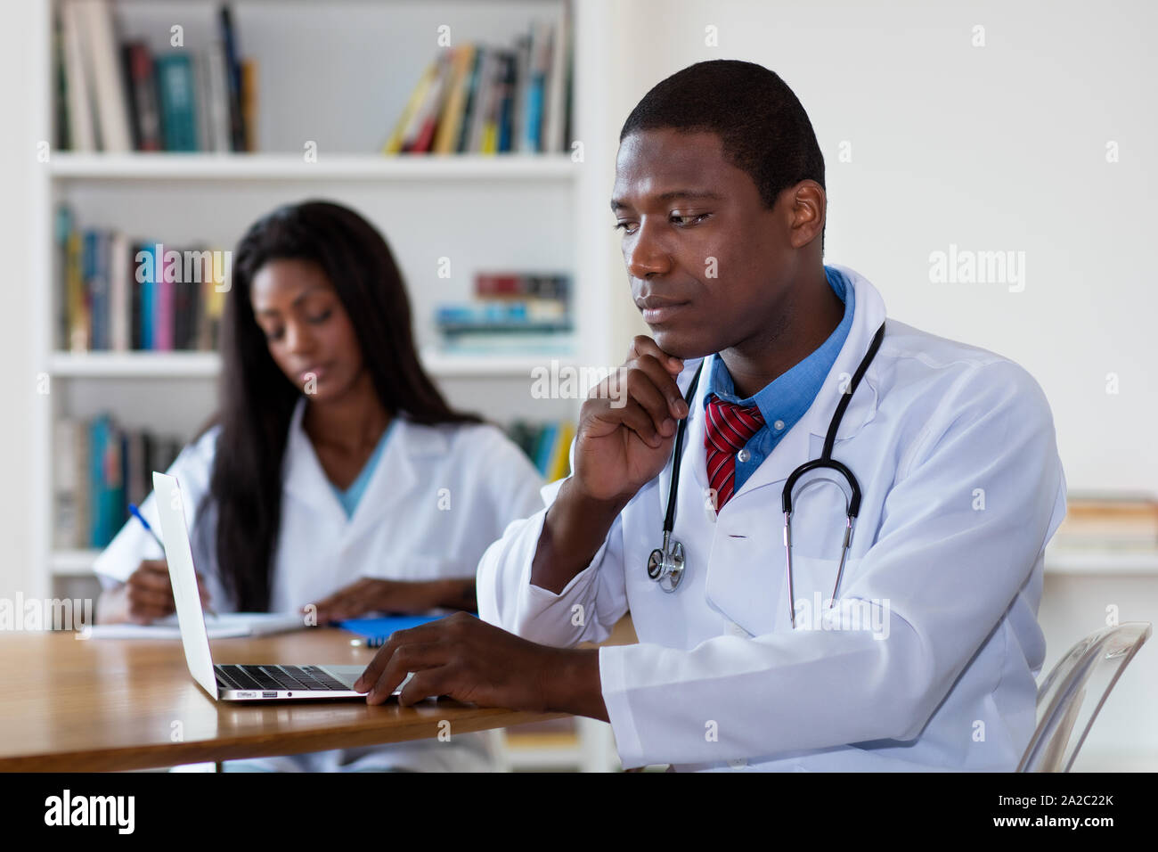 African american doctor at work with nurse at hospital Stock Photo - Alamy