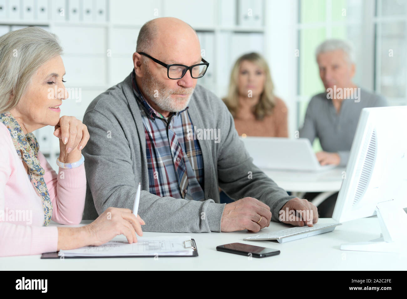 Portrait of senior business people working in office Stock Photo - Alamy