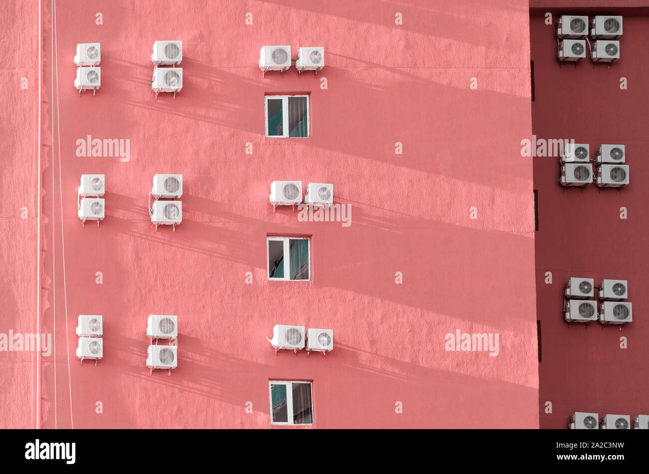 Colored wall of residential building with windows and a condensing unit ...