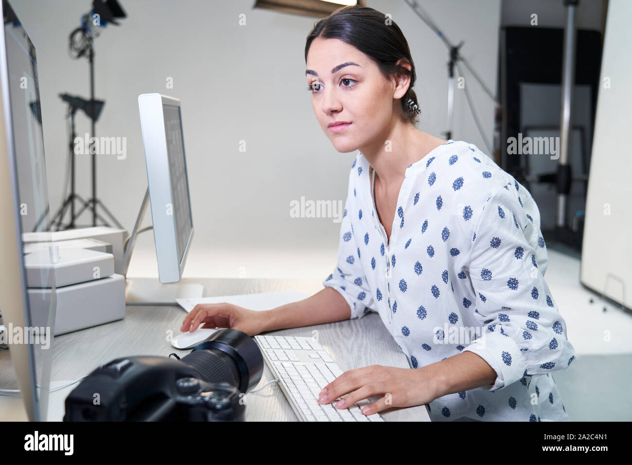 Female Photographer In Studio Reviewing Images From Photo Shoot On ...