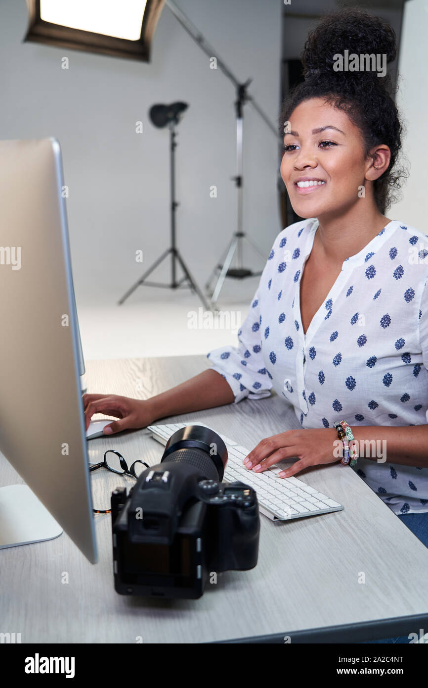 Female Photographer In Studio Reviewing Images From Photo Shoot On ...