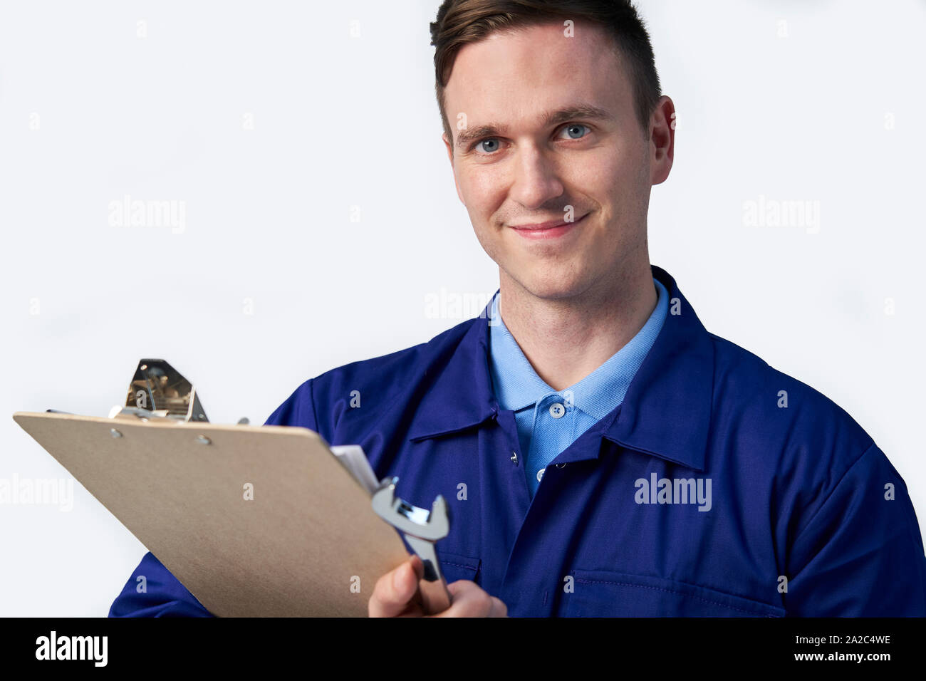 Studio Portrait Of Male Engineer With Clipboard And Spanner Against ...
