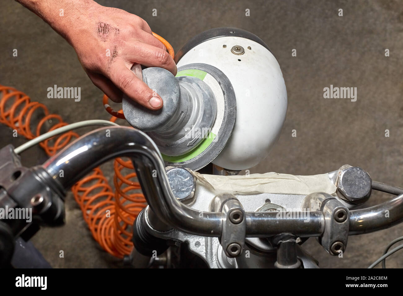 man's dirty scratched hand is holding a pneumatic grinder with an ...