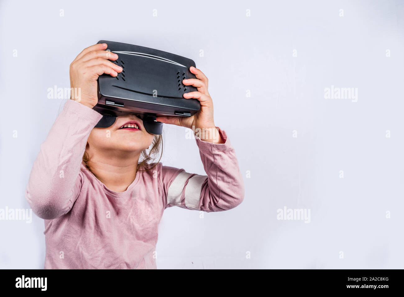 Happy little girl with virtual reality headset glasses. Innovation and ...
