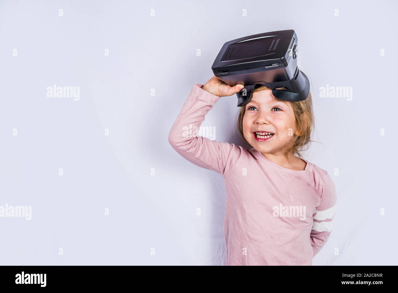 Happy little girl with virtual reality headset glasses. Innovation and ...