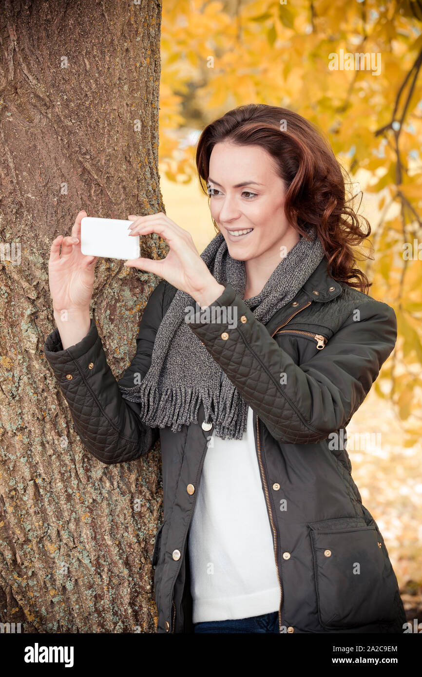 Young woman out on a walk taking pictures and self portraits on her ...