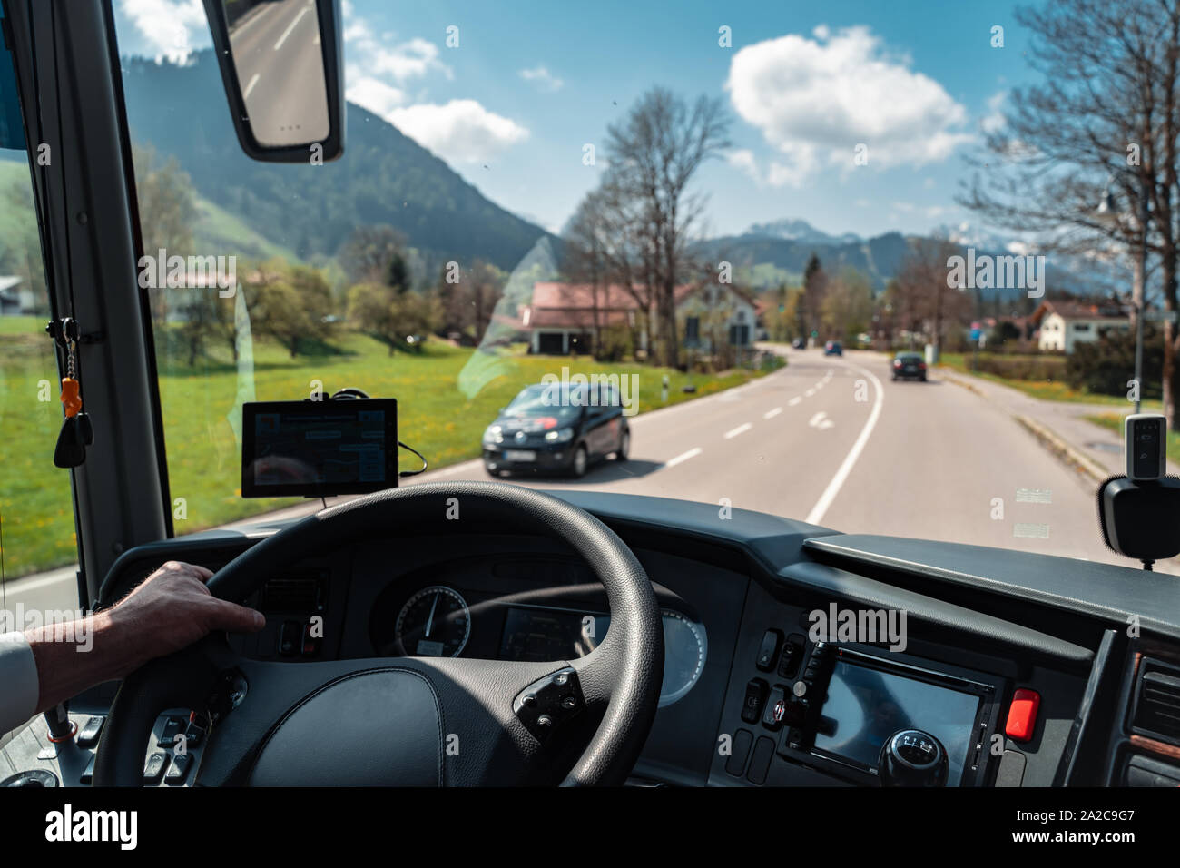 Scenic mountain and highway view through the driver's window of a bus ...