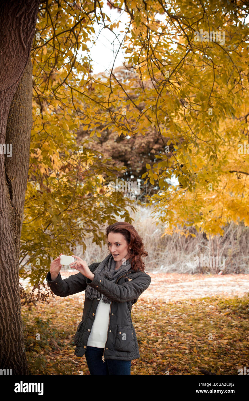 Young woman out on a walk taking pictures and self portraits on her ...