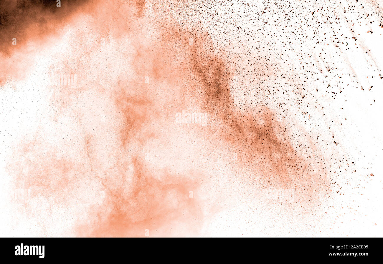 Abstract light orange powder explosion on white background. Freeze ...