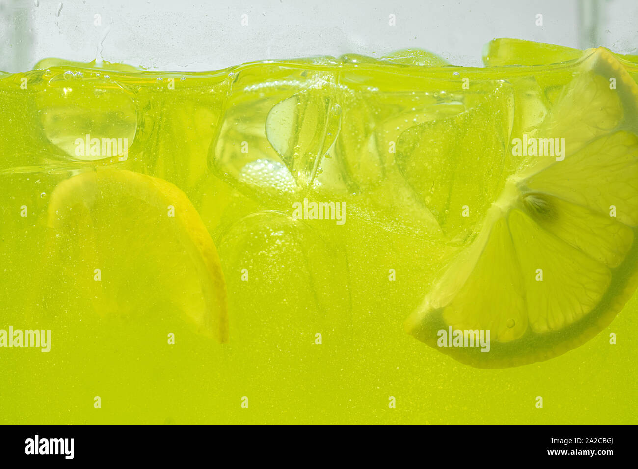 Close up view of the lemon slices in lemonade background. Texture of ...