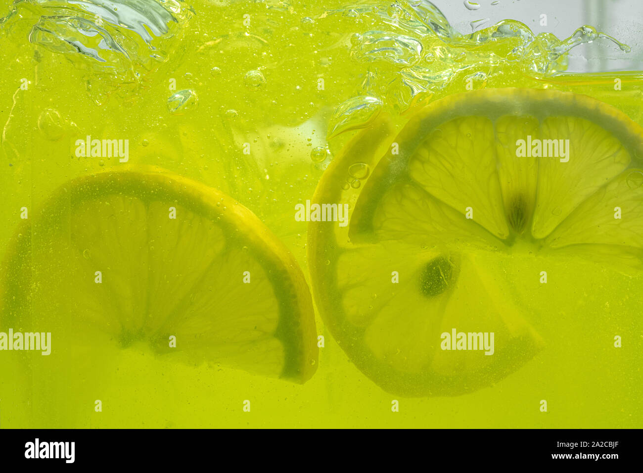 Close up view of the lemon slices in lemonade background. Texture of ...