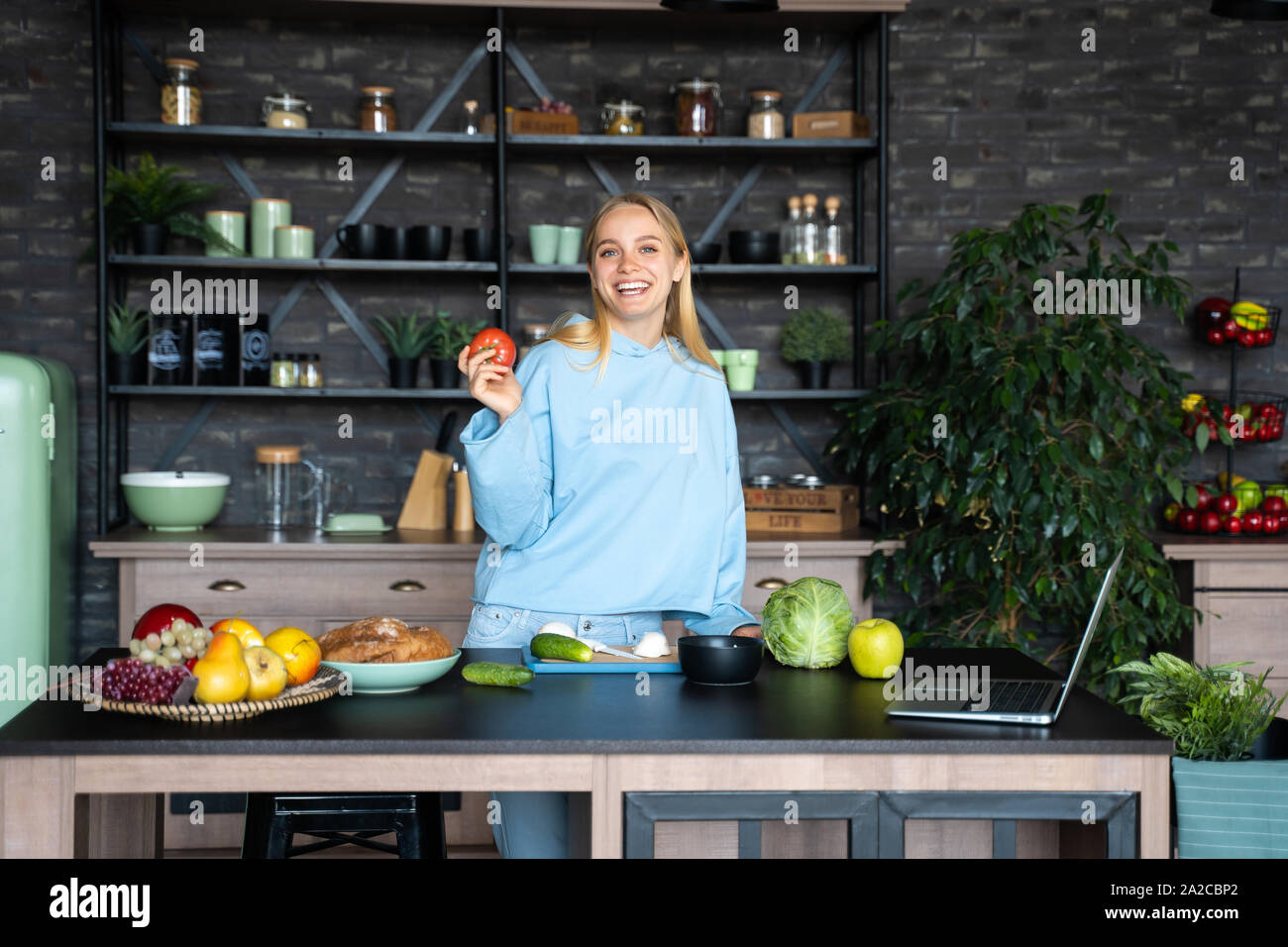 Beautiful young girl posing in the kitchen, smiling and having fun ...
