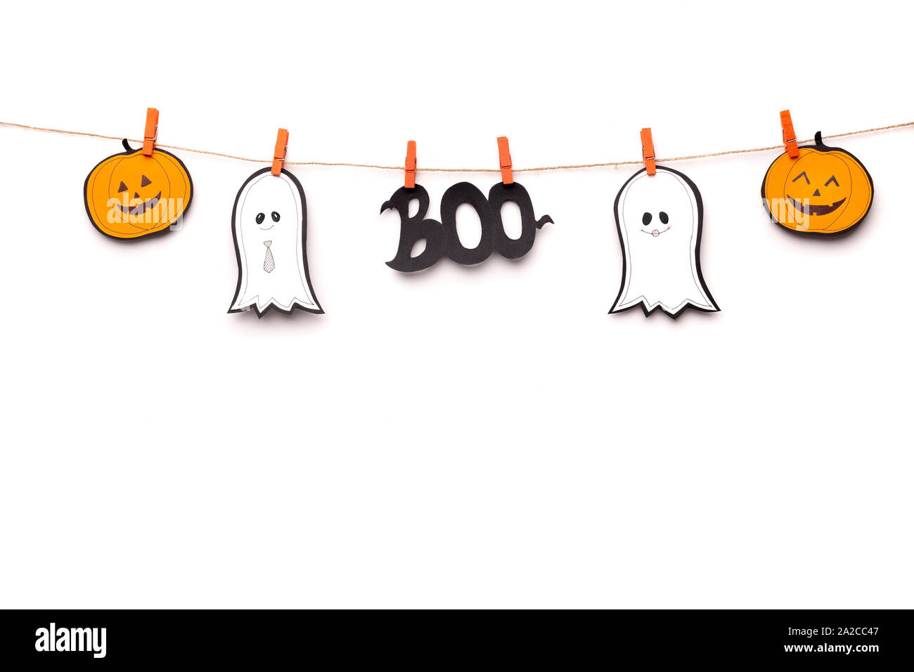 Halloween cut out smiling figures hanging on rope Stock Photo - Alamy