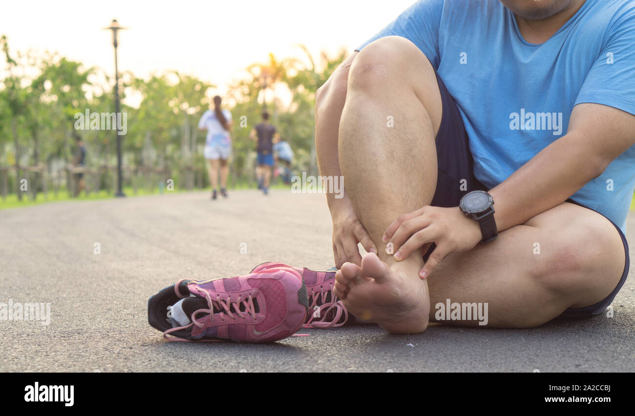 Ankle sprained. Fat man suffering from an ankle injury while running at ...