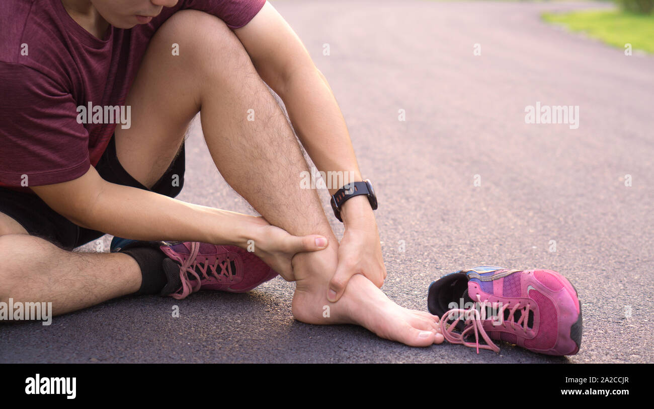 Ankle sprained. Young man suffering from an ankle injury while running ...