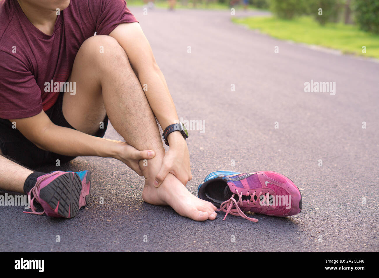 Ankle sprained. Young man suffering from an ankle injury while running ...