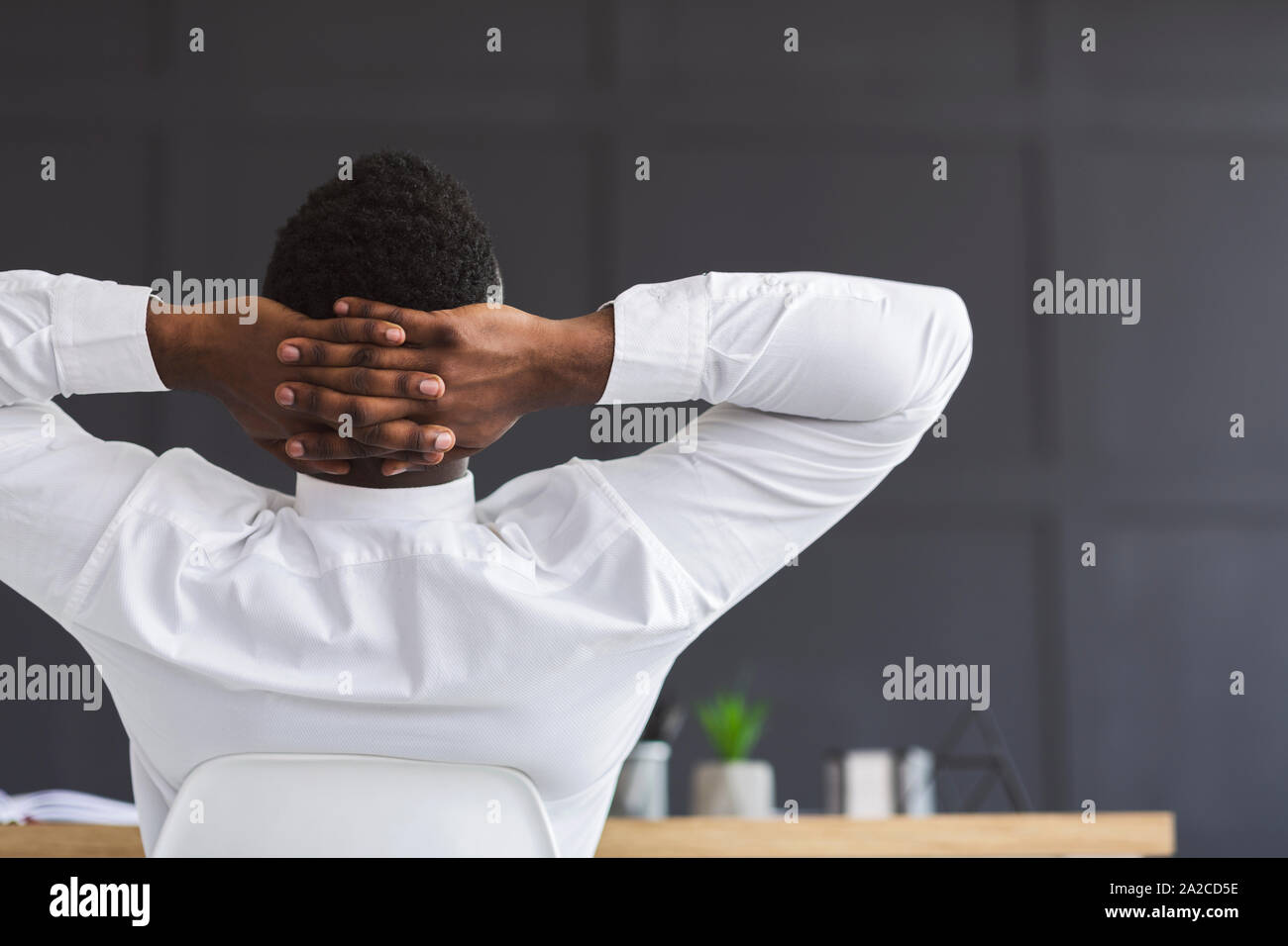 Back view of black employee relaxing in office Stock Photo - Alamy