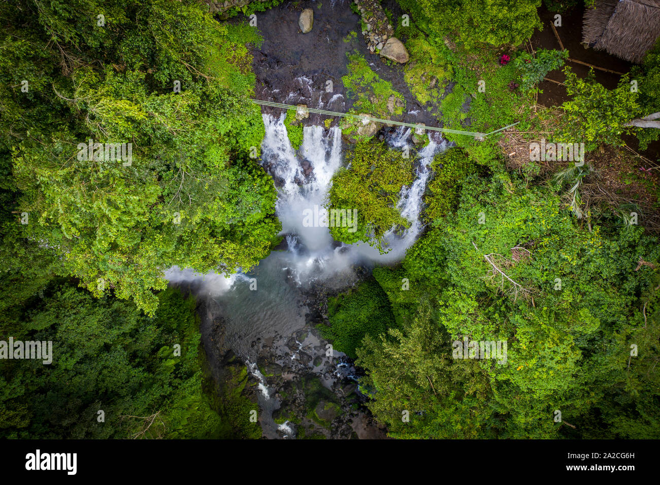 Aerial view looking straight down a waterfall in dense rainforest in ...