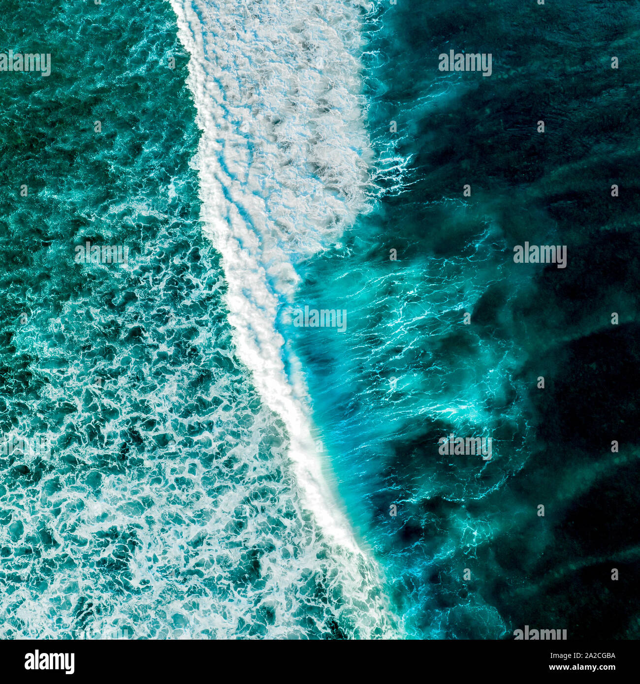 Aerial view looking straight down onto large waves in a tropical ocean ...
