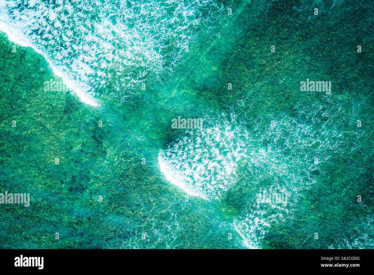 Aerial view looking straight down onto large waves in a tropical ocean ...