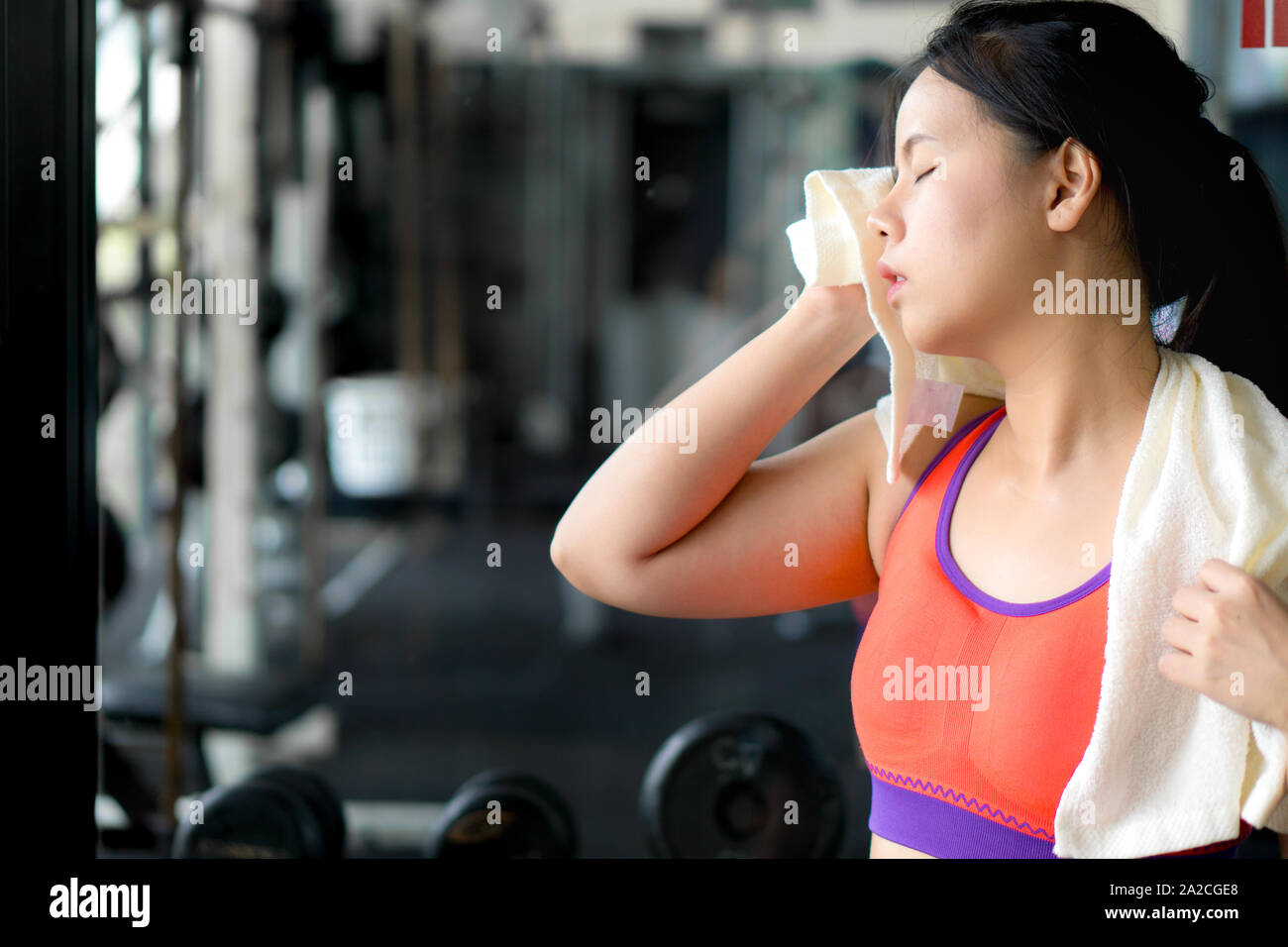 Asian beauty woman wiping sweat with towel at fitness gym. Diet, weight ...
