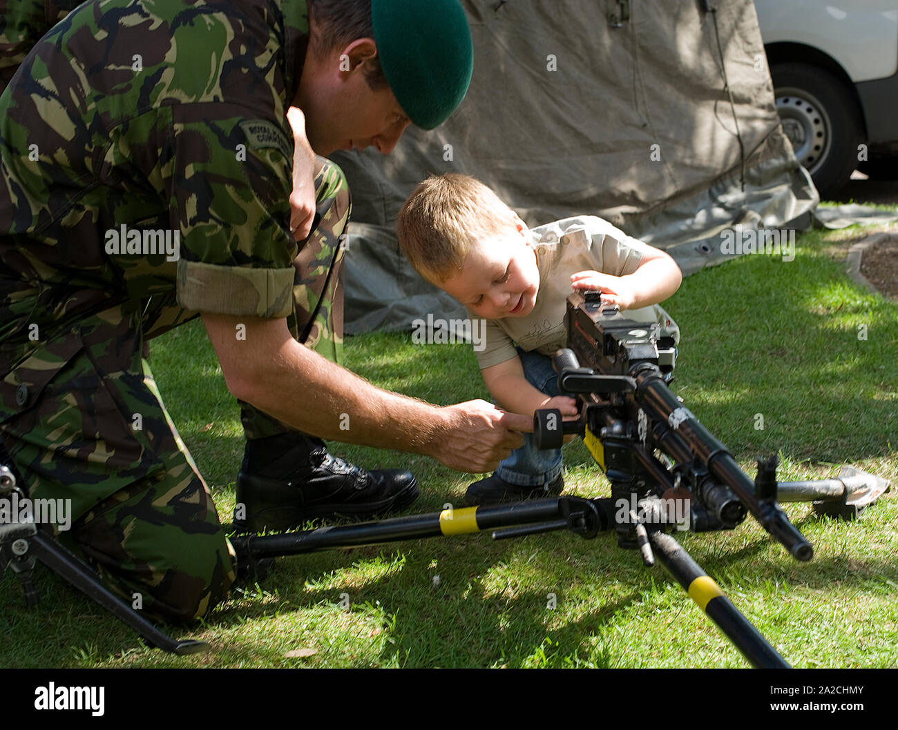 Solider showing machine gun to little boy Stock Photo - Alamy