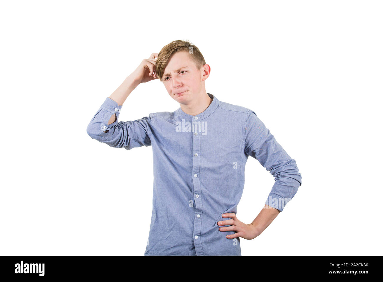 Pensive teenage boy scratching his head thinking, looking confused has ...