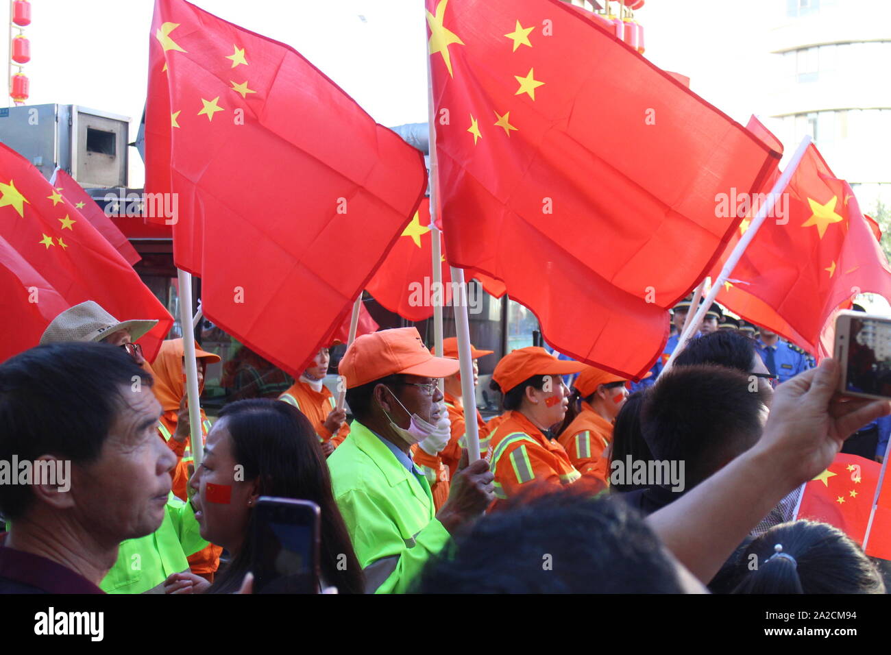 Yinchuan, Ningxia, China. 30th Sep, 2019. Workers wave a national flags ...