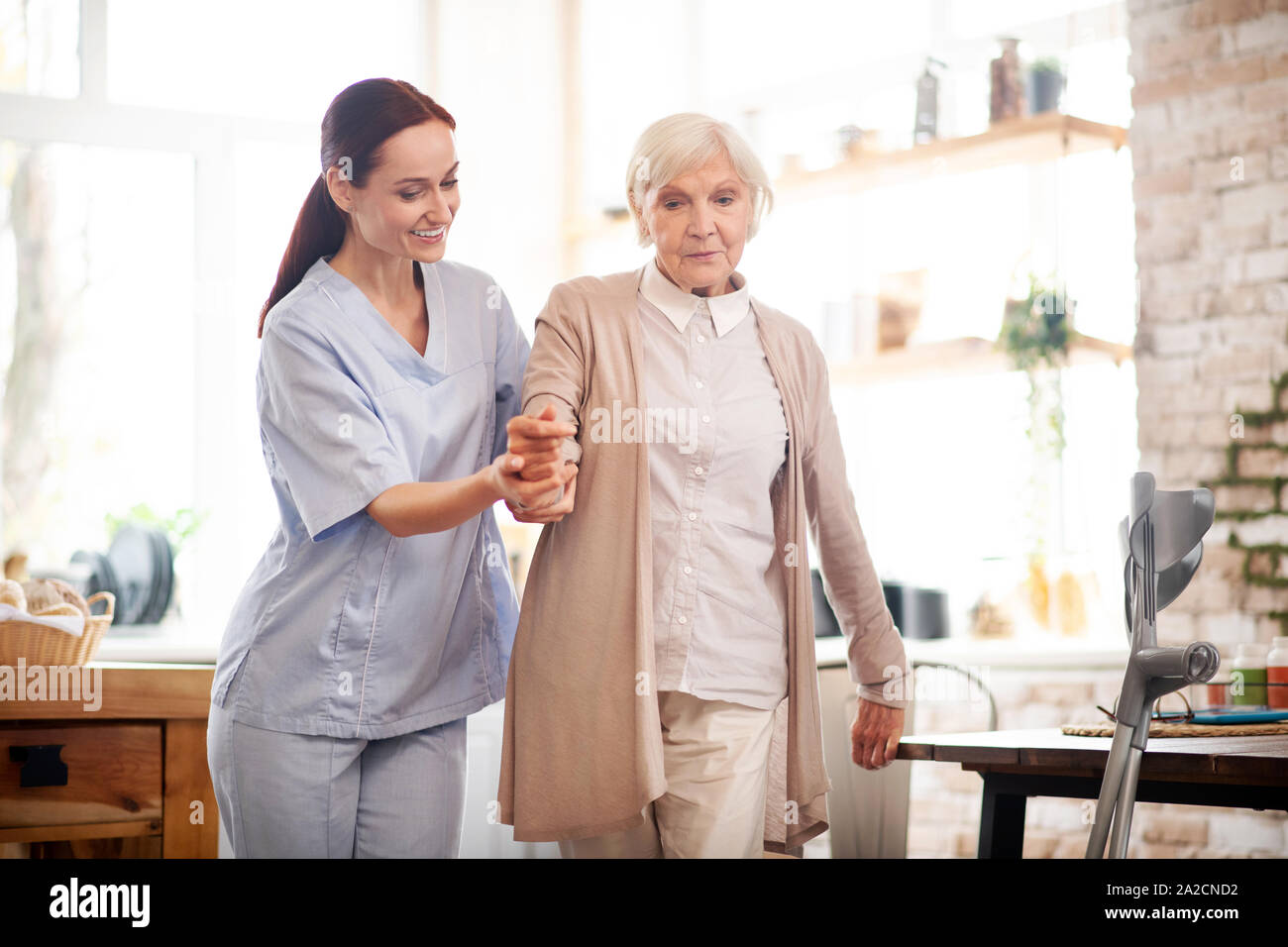 Aged woman walking after surgery with the help of nurse Stock Photo - Alamy
