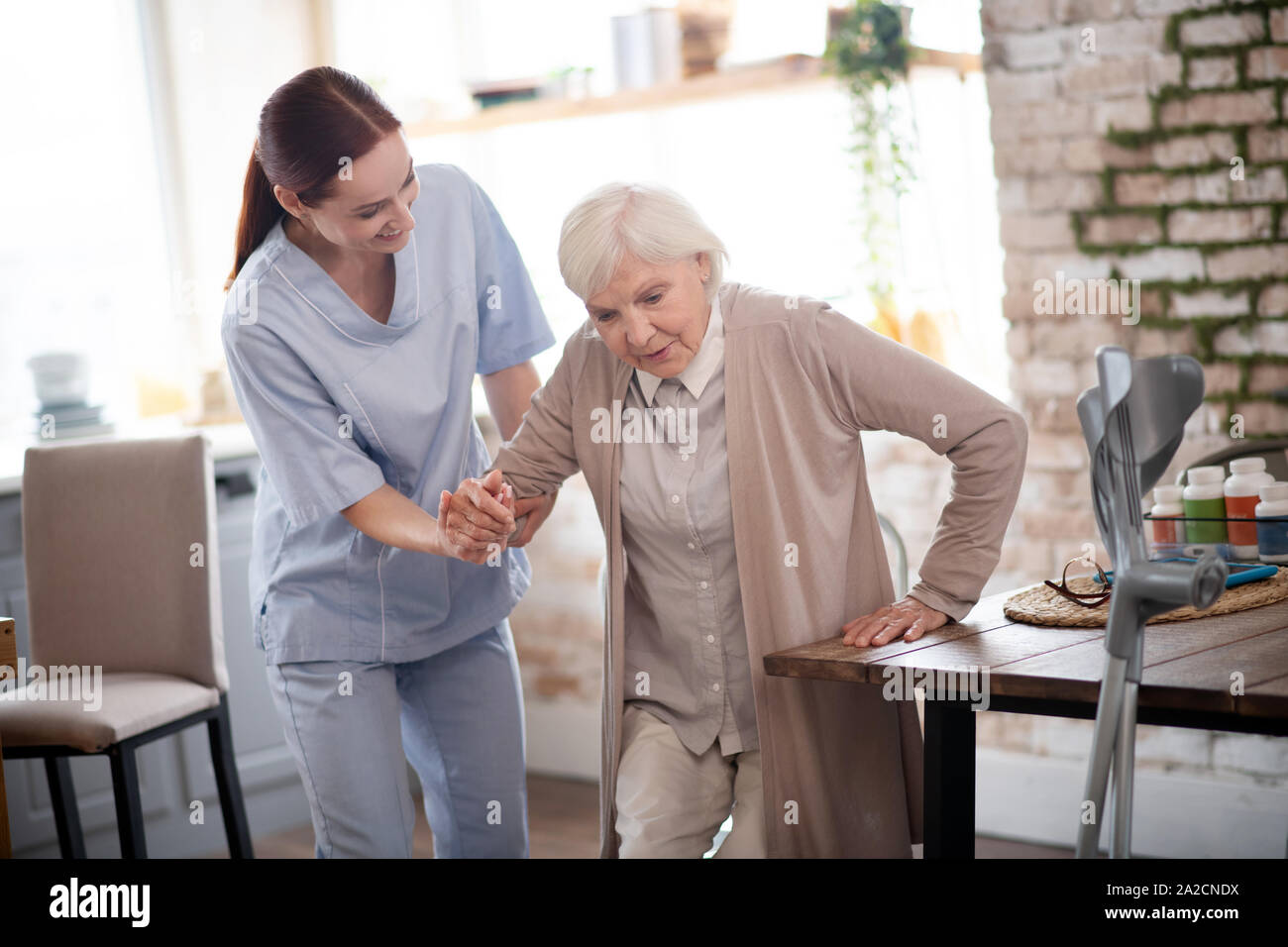 Grey-haired woman trying to walk after surgery Stock Photo - Alamy