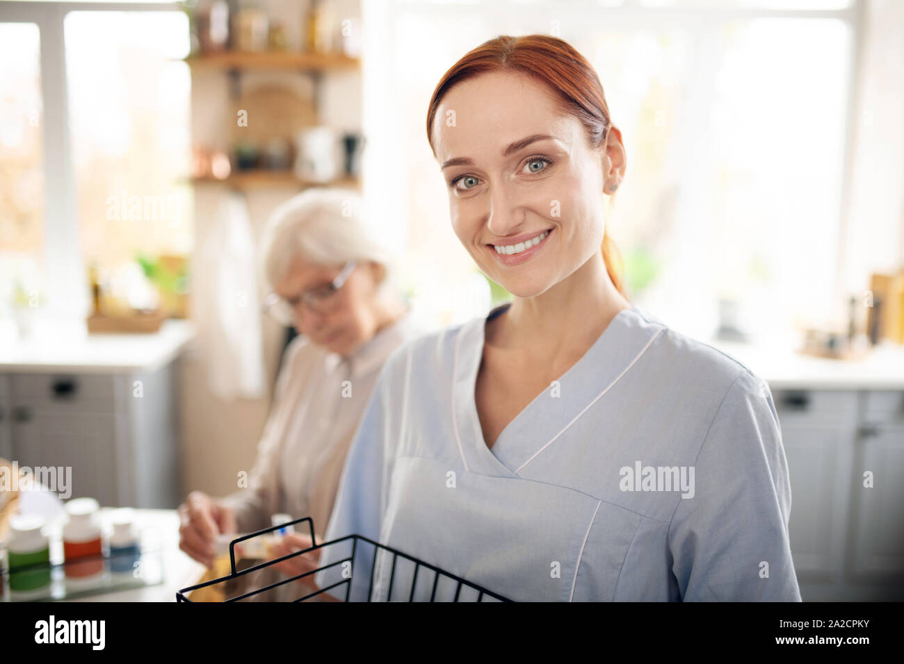 Beautiful smiling caregiver enjoying her work Stock Photo - Alamy