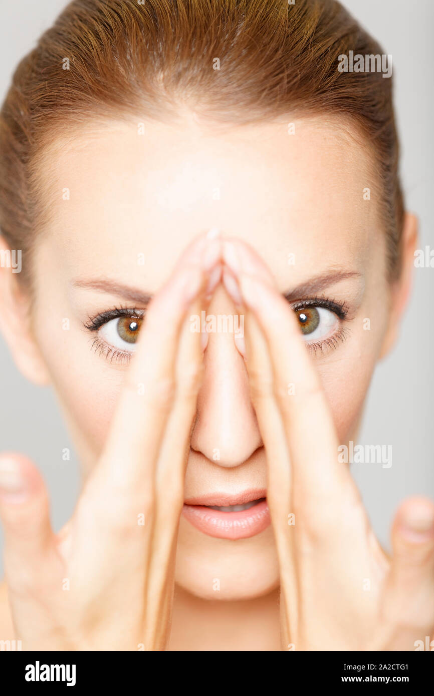 Beautiful young woman with her hand covering part of her face in a ...