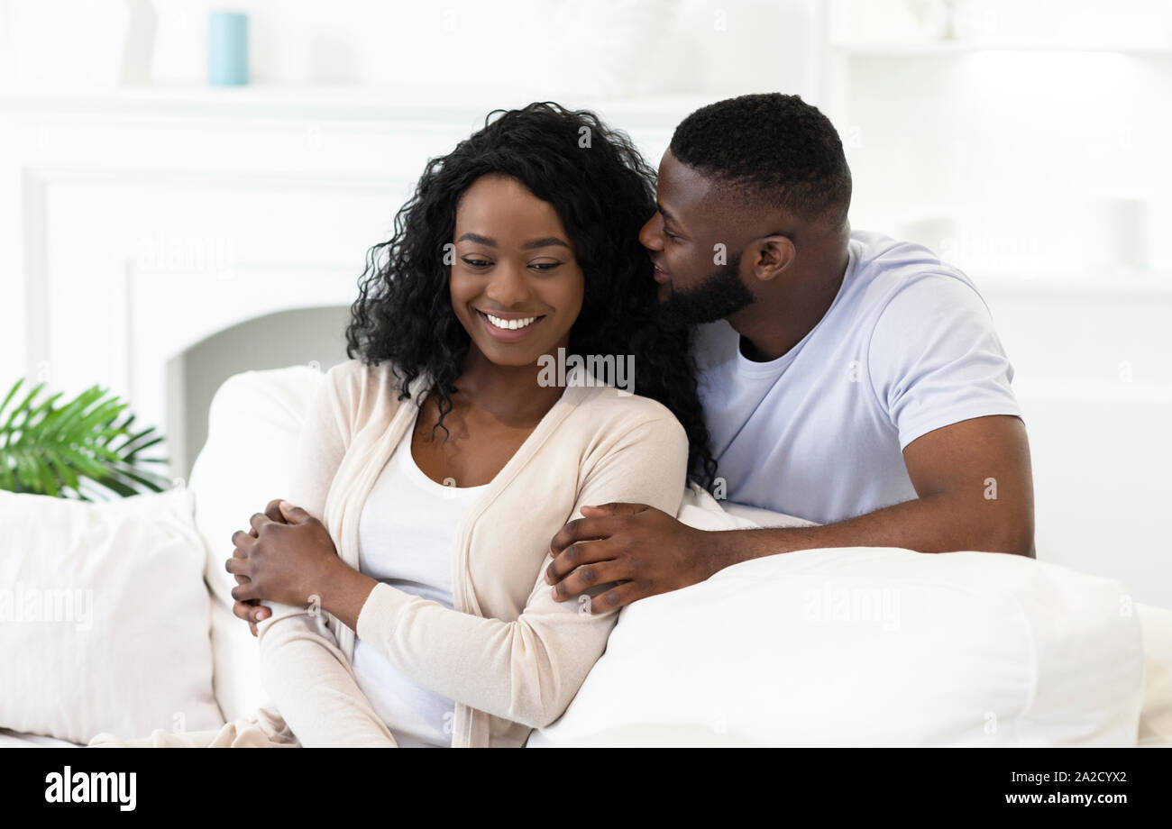 Handsome black guy whispering something to his girlfriend's ear Stock ...