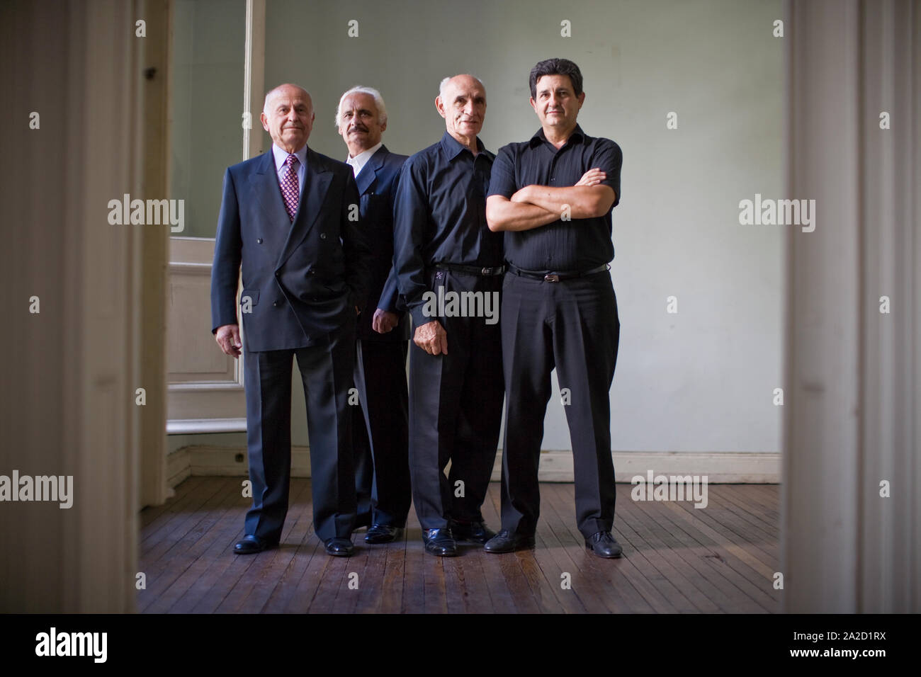 Portrait of a smiling mature adult man folding his arms while standing ...