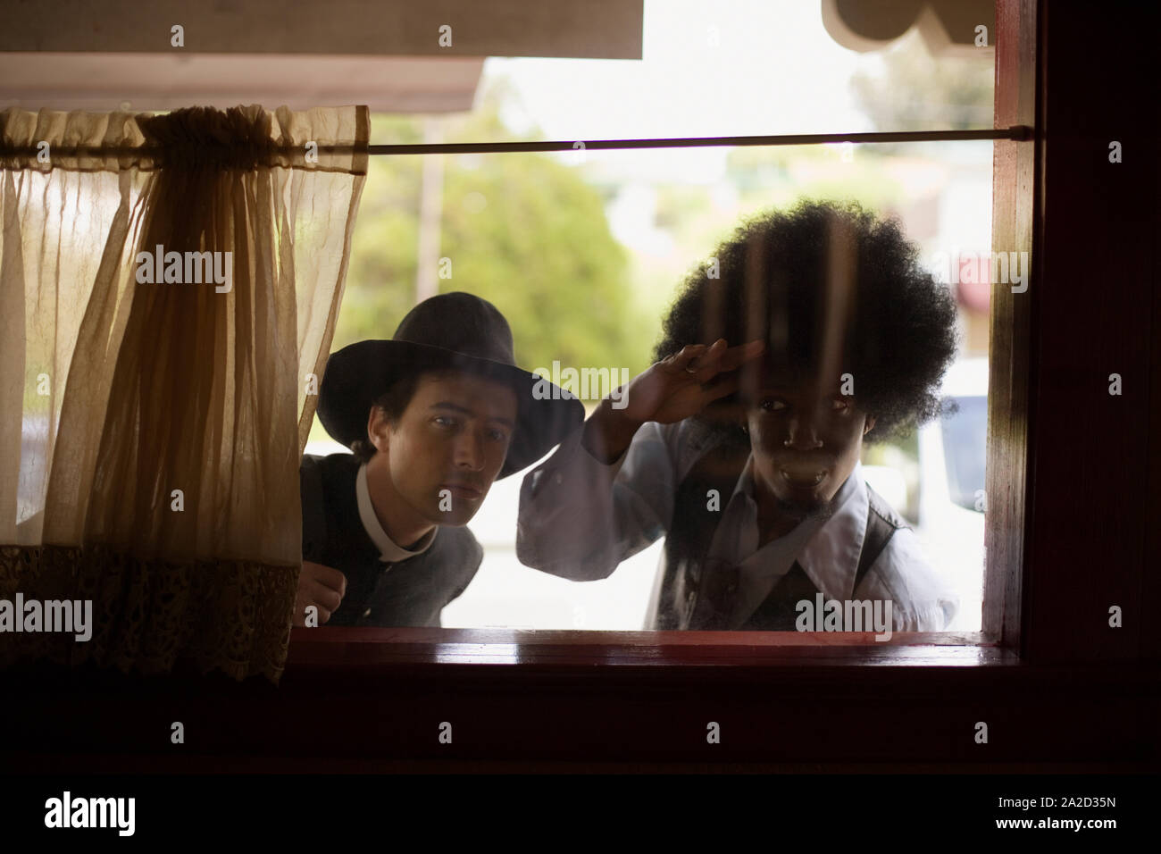 View of two people peeping through a window Stock Photo - Alamy