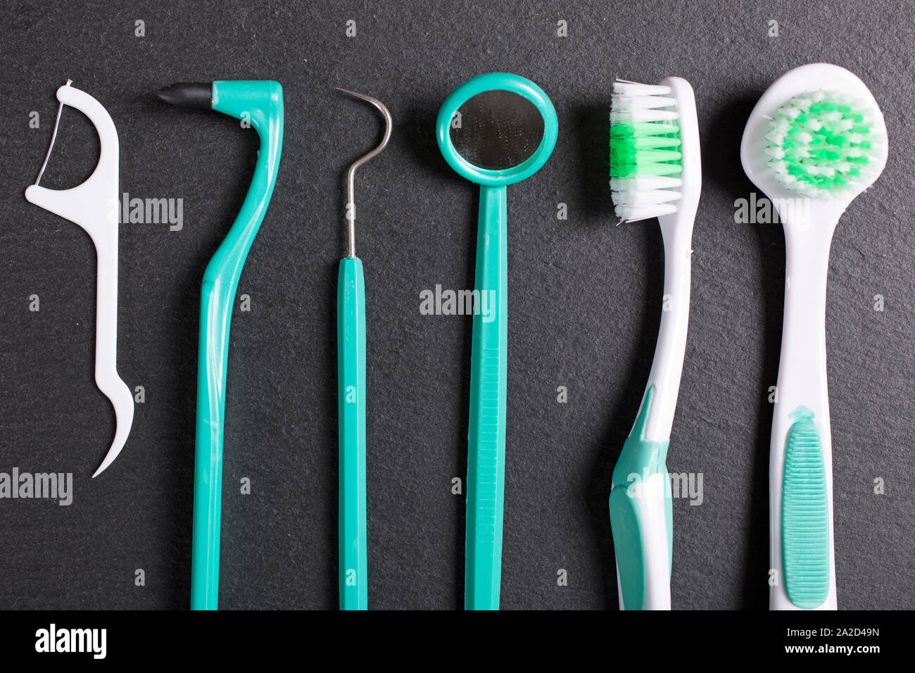 Selection of dentist brushes and tools on a black slate surface Stock ...