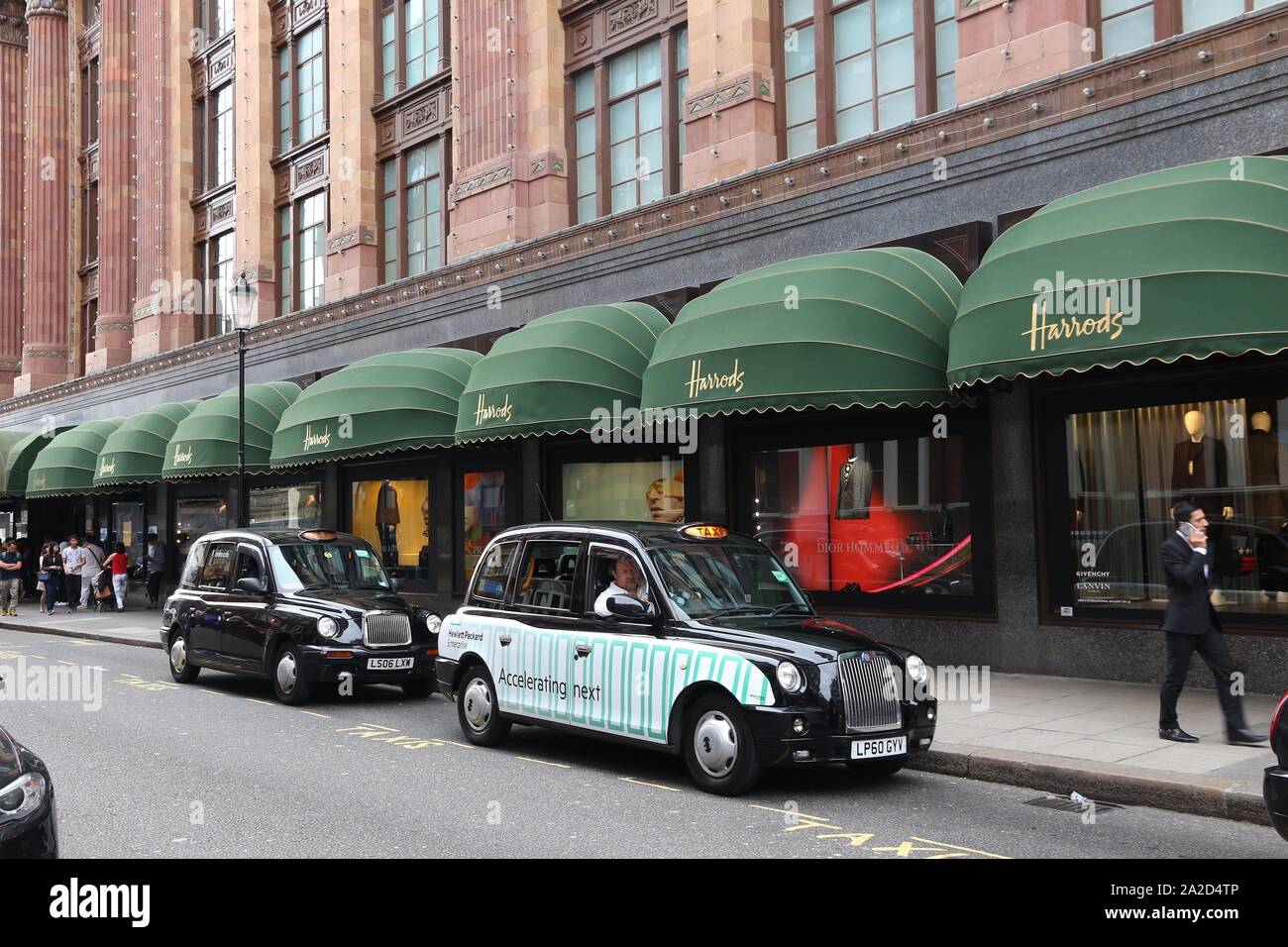LONDON, UK - JULY 9, 2016: Black cabs wait at Harrods department store ...