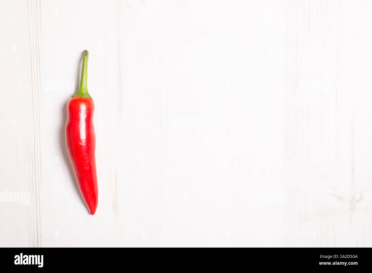 Fresh red chilli on a light wooden kitchen work surface Stock Photo - Alamy